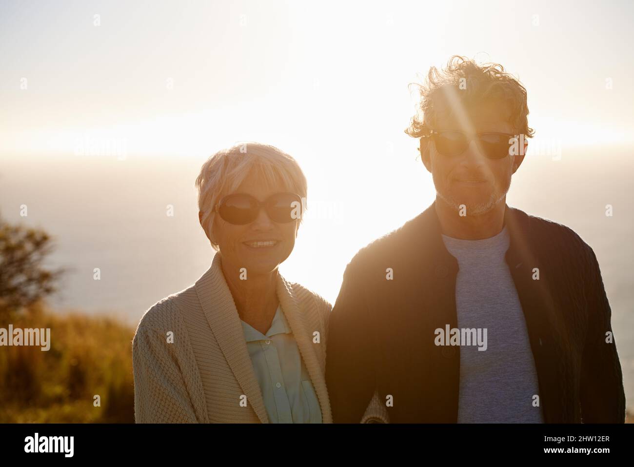 Enjoying a sunset. Cropped view of a senior couple standing on a ...