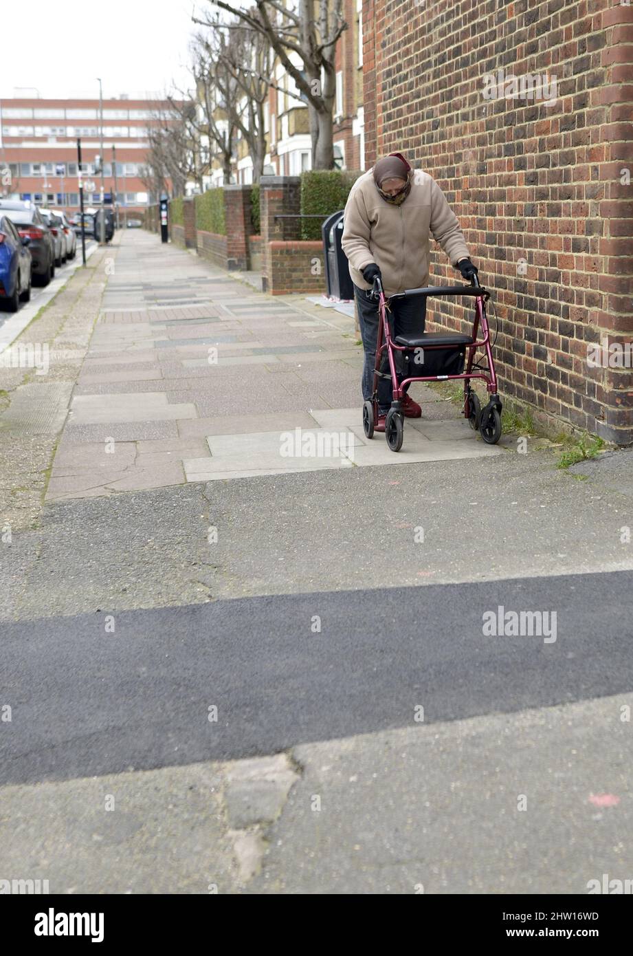 London, England, UK. Elderly woman using a wheeled walking frame ...