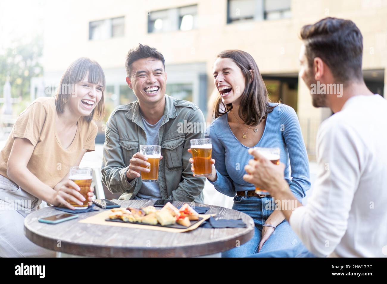 Happy multiracial friends group drinking beer at brewery pub restaurant ...