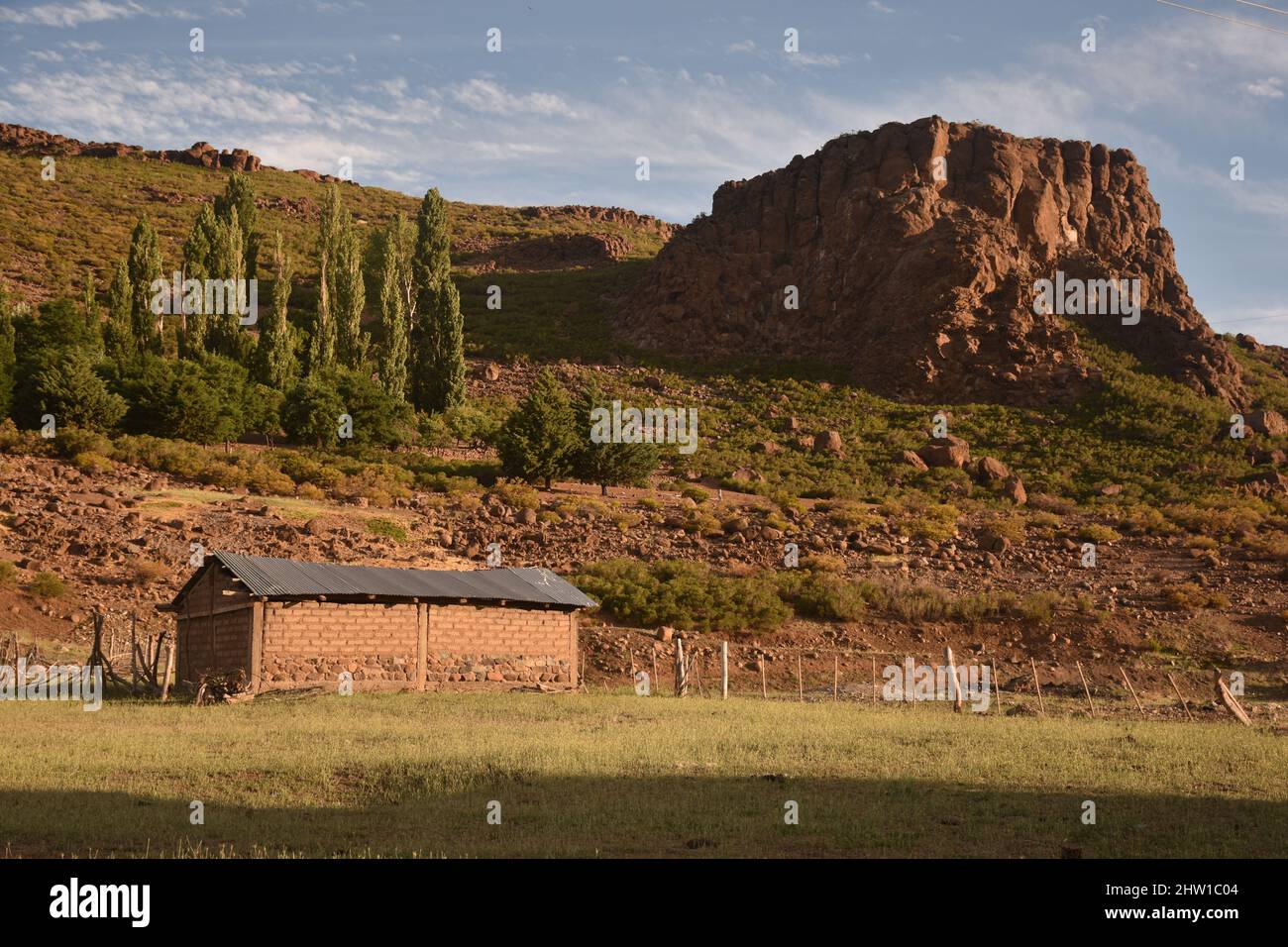 Stone barn against the background of massive rock Stock Photo - Alamy