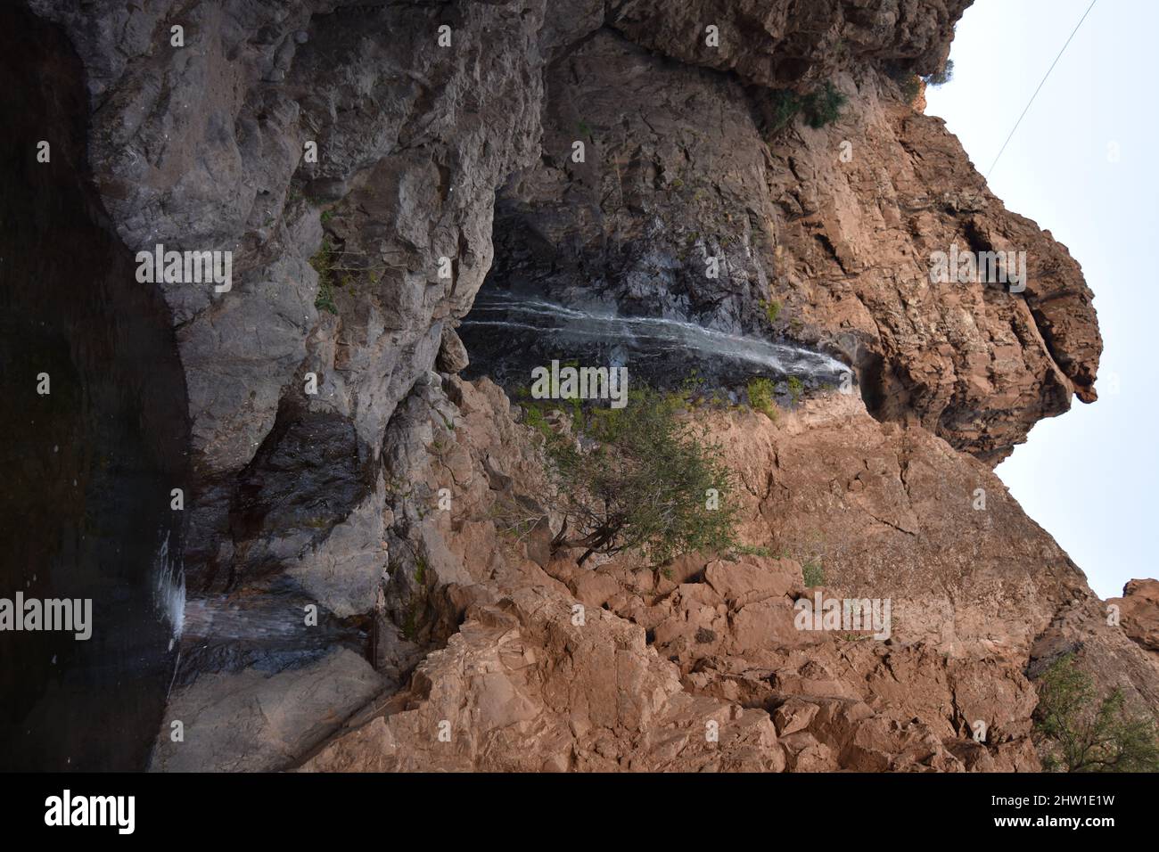 Vertical shot of the massive rocks with a thin waterfall Stock Photo ...
