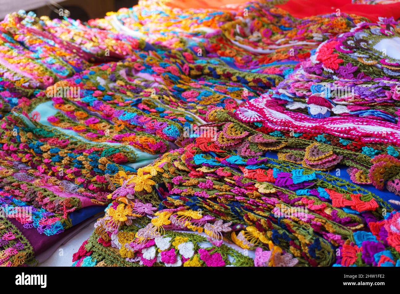Stack of colorful handmade crochet lace products in woman producer ...