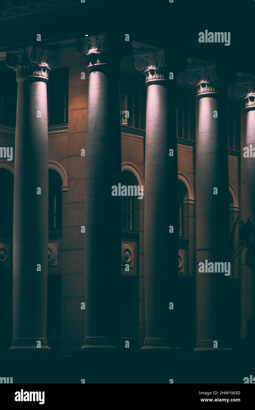 Vertical of an antique style building with columns illuminated at night ...
