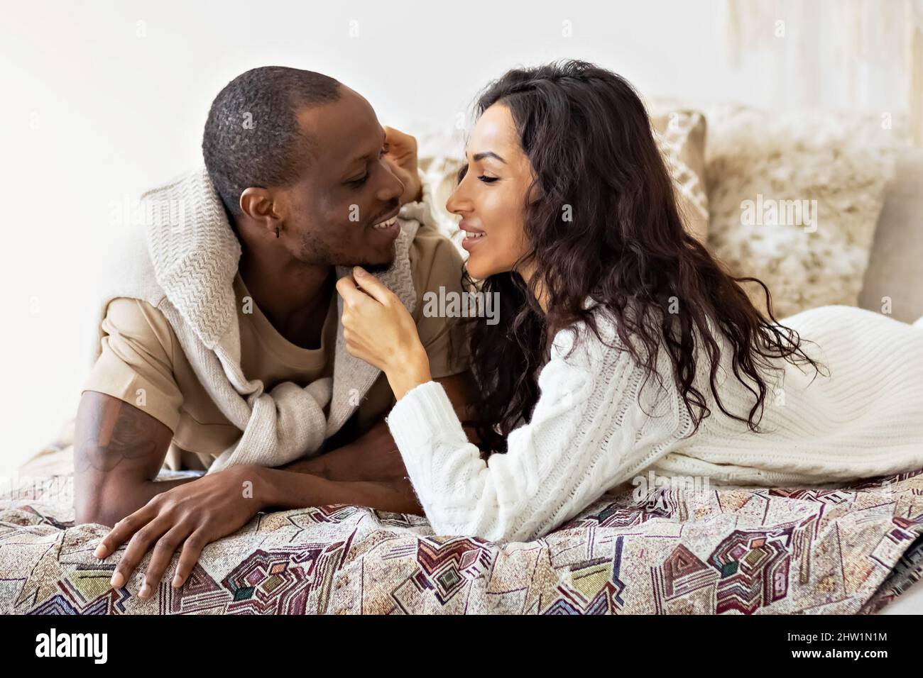 Black Man And Woman Cuddling In Bed
