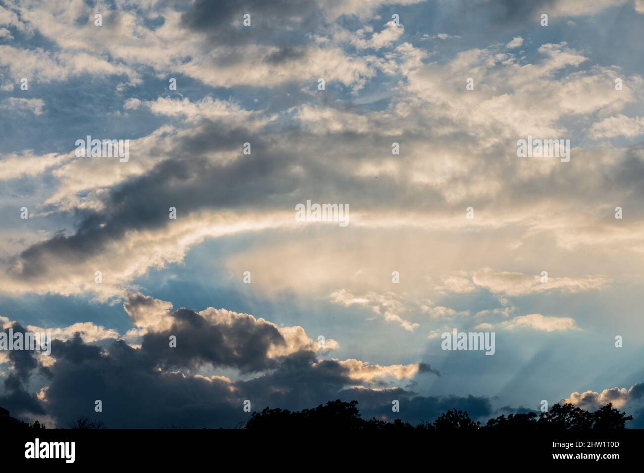 the sky is covered with dark gloomy clouds and the sun's rays seep ...