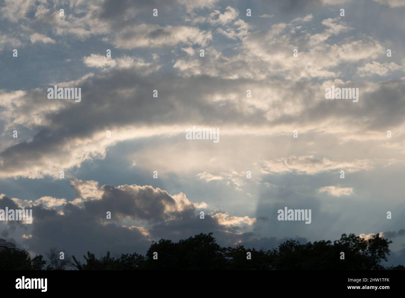 the sky is covered with dark gloomy clouds and the sun's rays seep ...