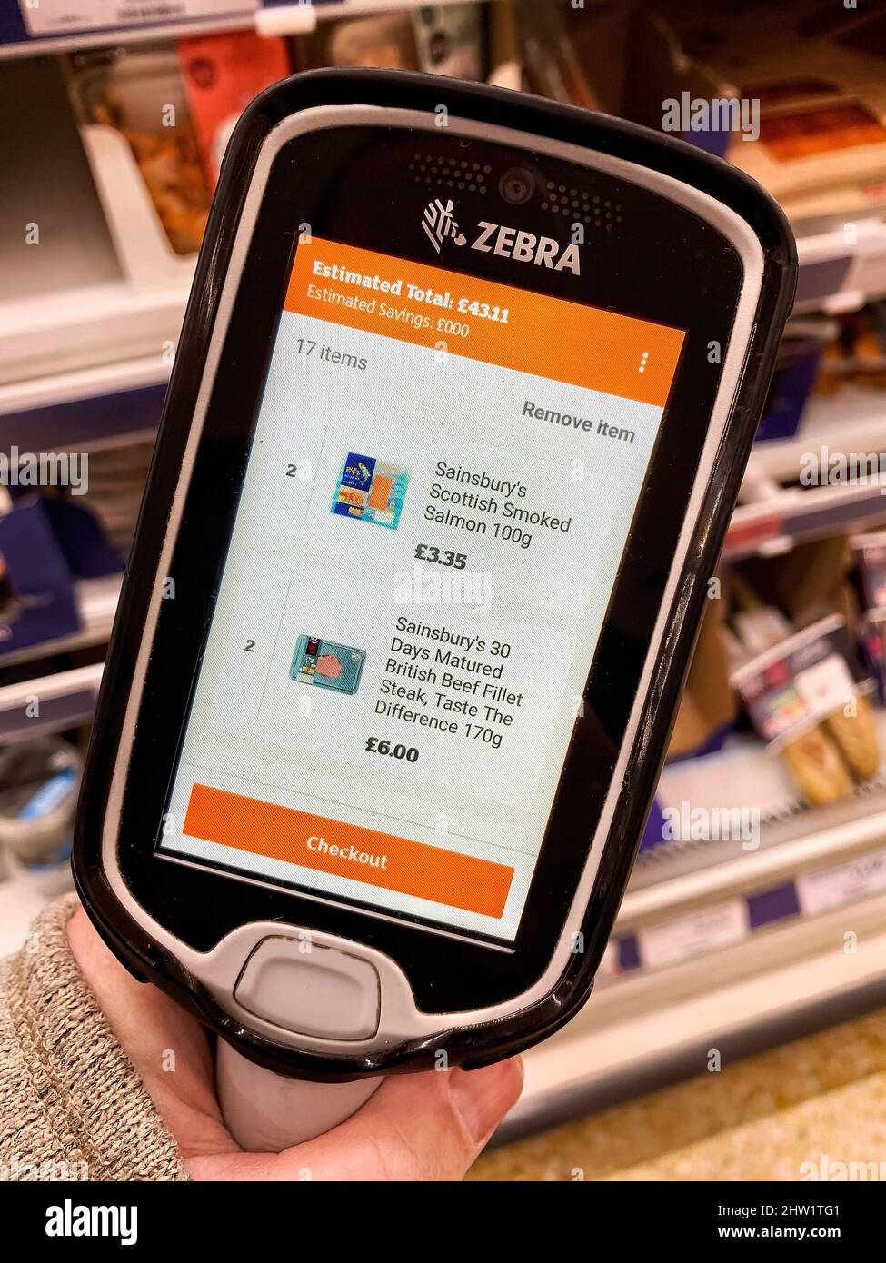 Closeup of a Sainsbury's Smart Shop handset in a customer's hand in a ...