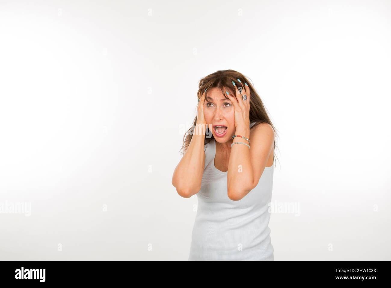 portrait adult woman screaming with hands on head on white background ...