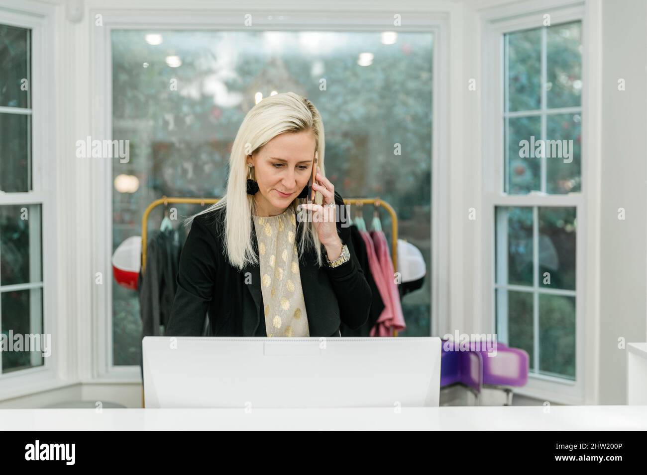 A female small business owner of a medical spa and retail shop standing ...