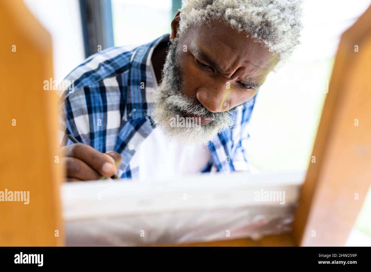 Focused senior african american man painting on easel at home Stock ...