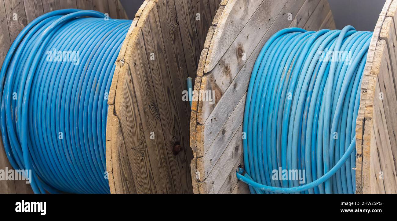New blue power cable is wound on wooden coil. Background. Cable for ...