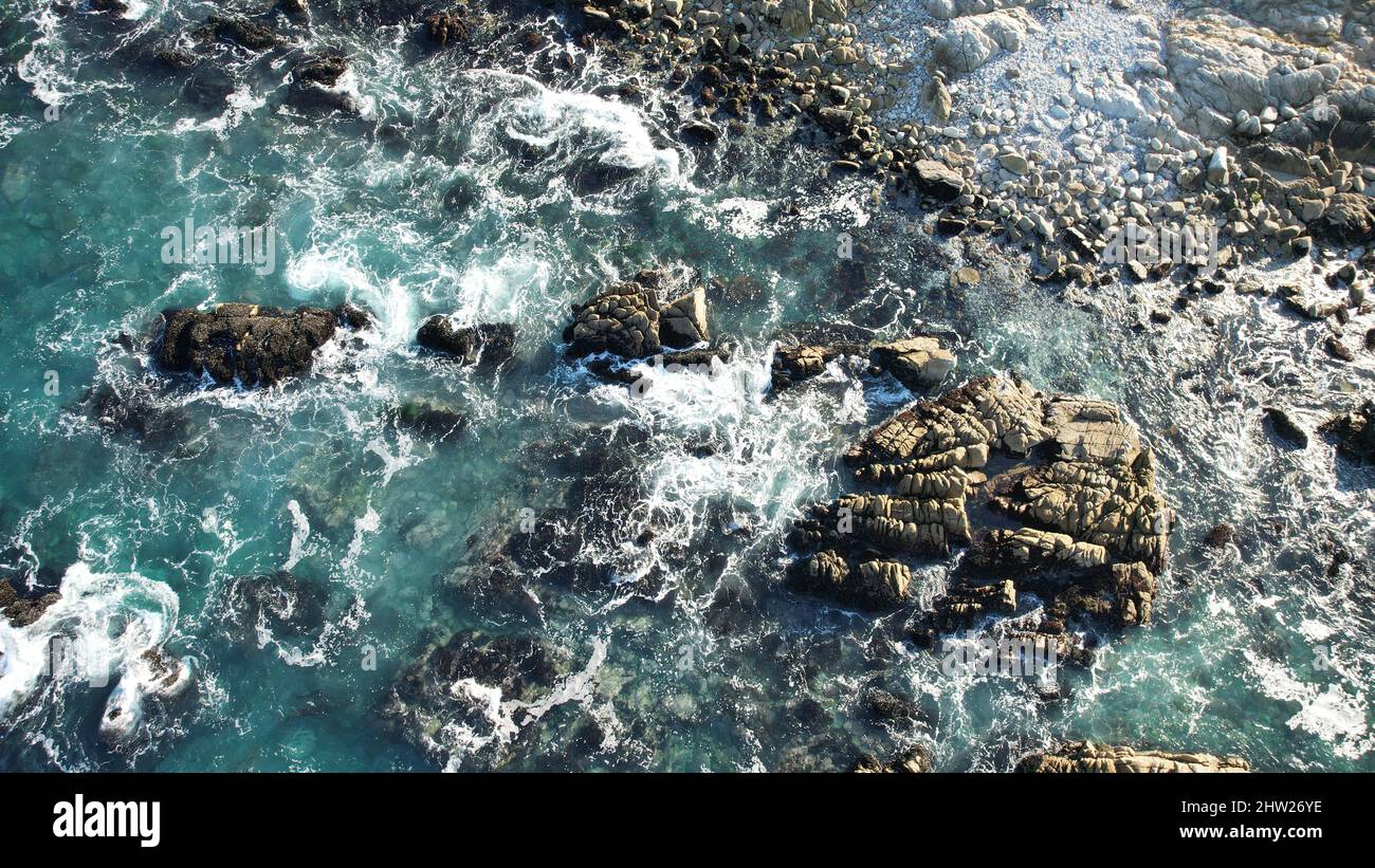Beautiful view of sea foamy waves splashing against the rocky coast on ...