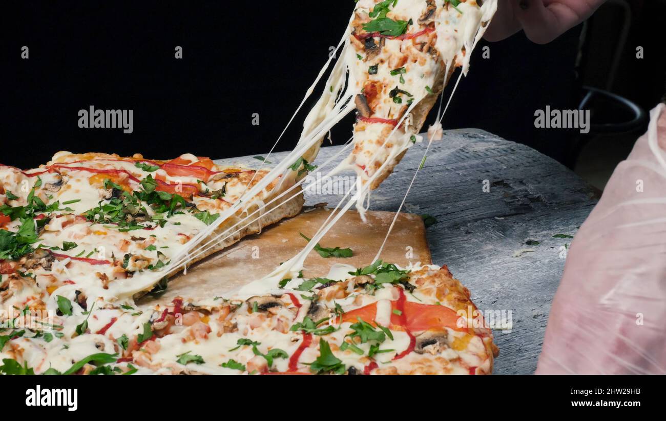 Man takes a piece of pizza with his hand. Frame. Male hand takes the ...