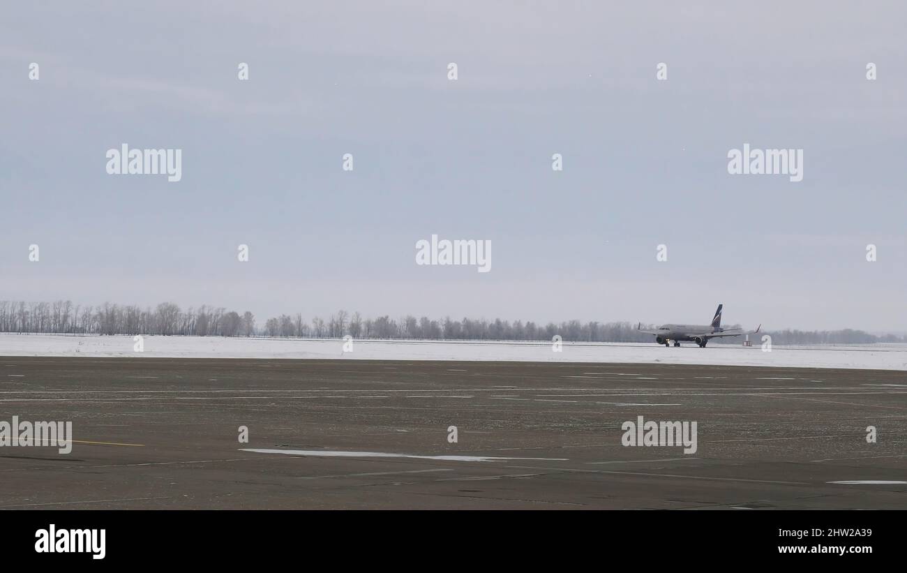 Plane is preparing to land along runway in winter. Plane on runway in ...