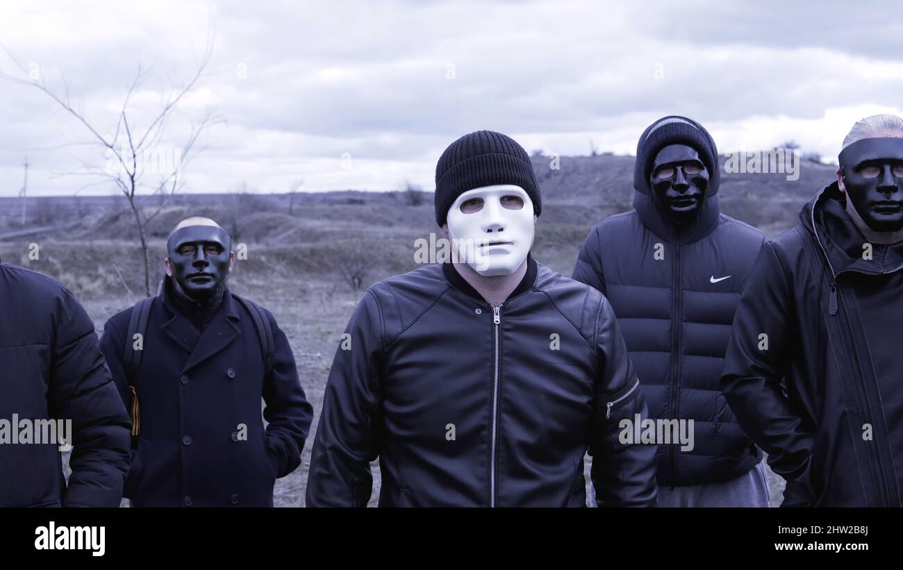 Men in black jackets and masks. Footage. Criminal gang in black plastic ...