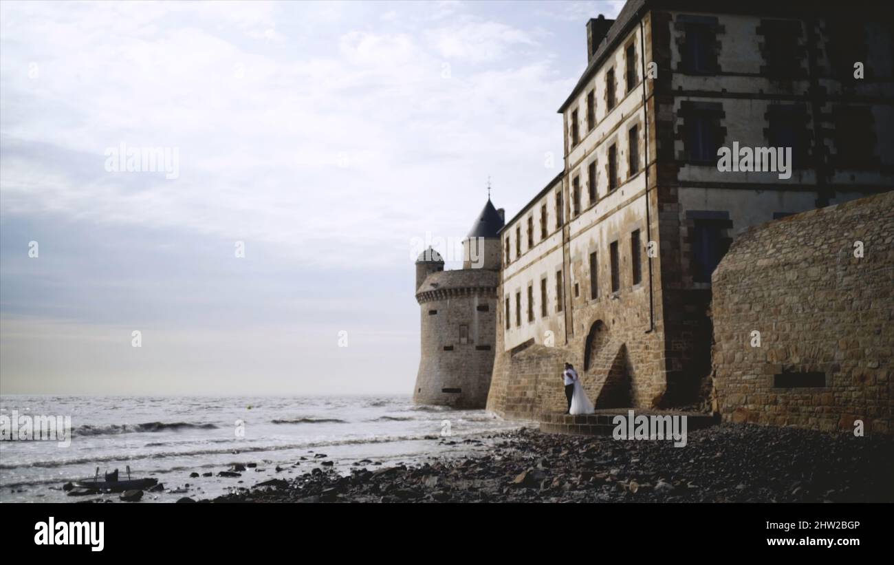 Couple of medieval coastal fortress. Action. Beautiful newlyweds stand ...