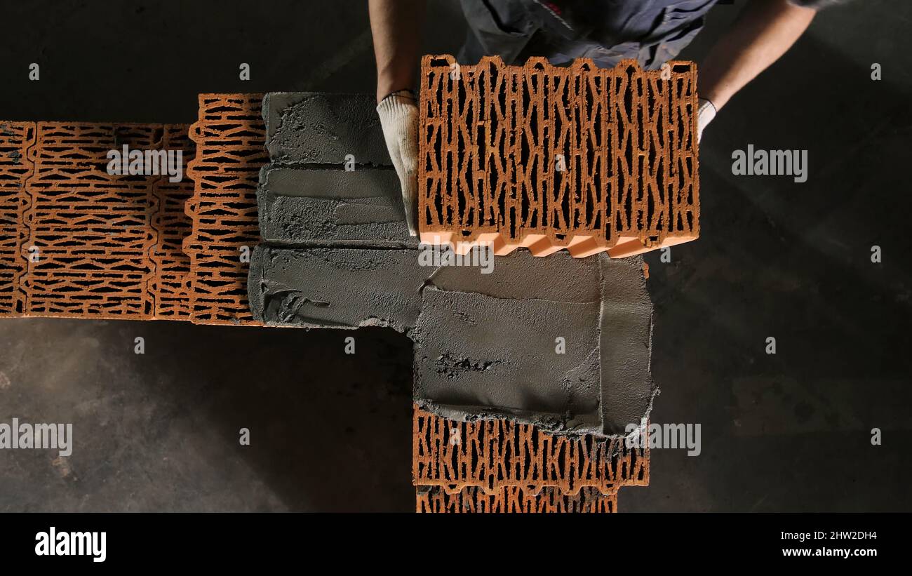 Close-up of man laying brick block on cement. Stock footage. Builder ...