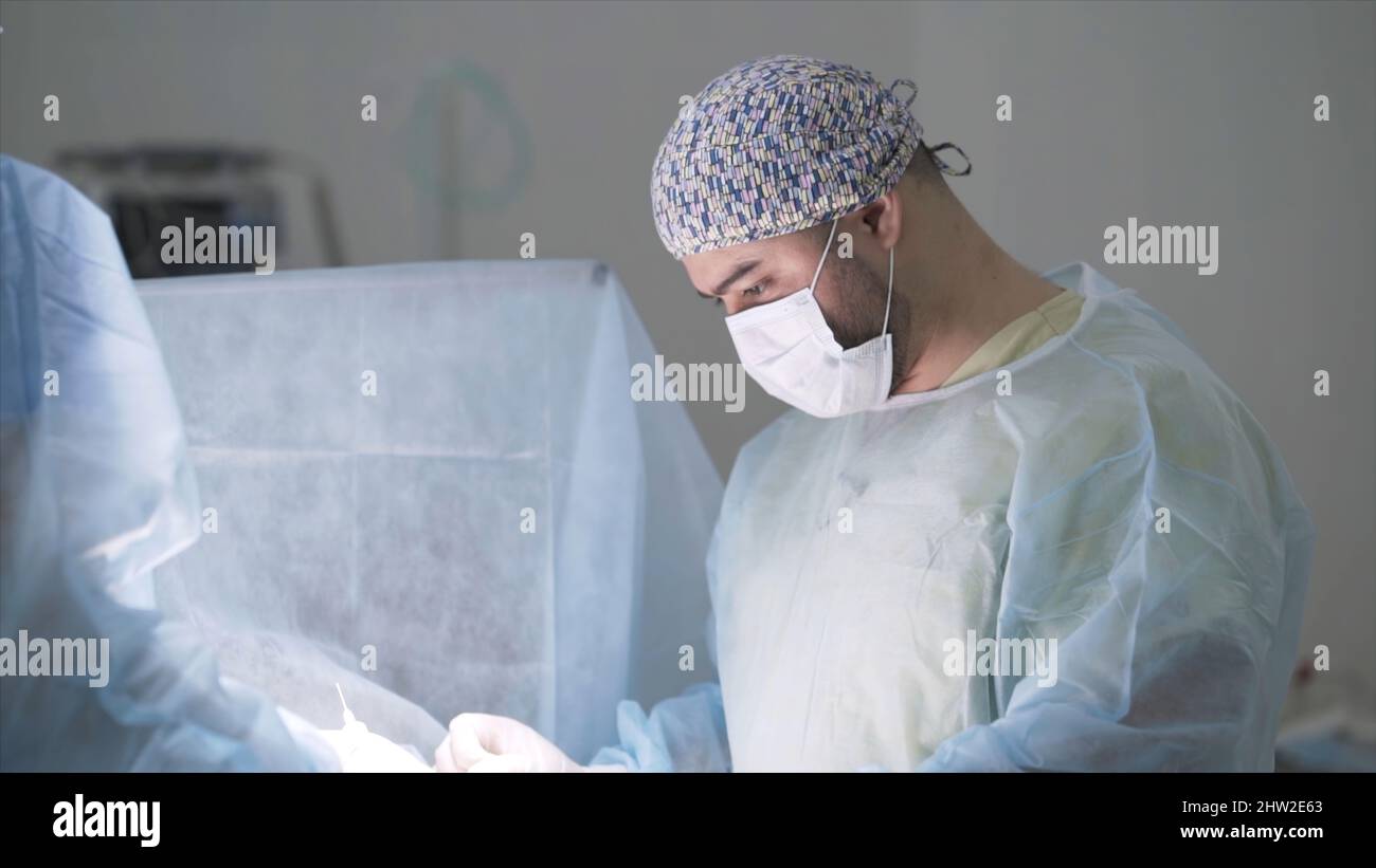 Professional surgeons operate on person under anesthesia. Action. Two ...