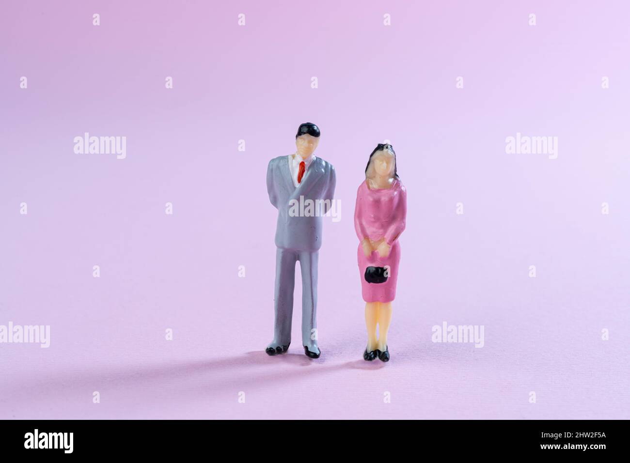 a couple of miniature people together on a colored surface Stock Photo ...