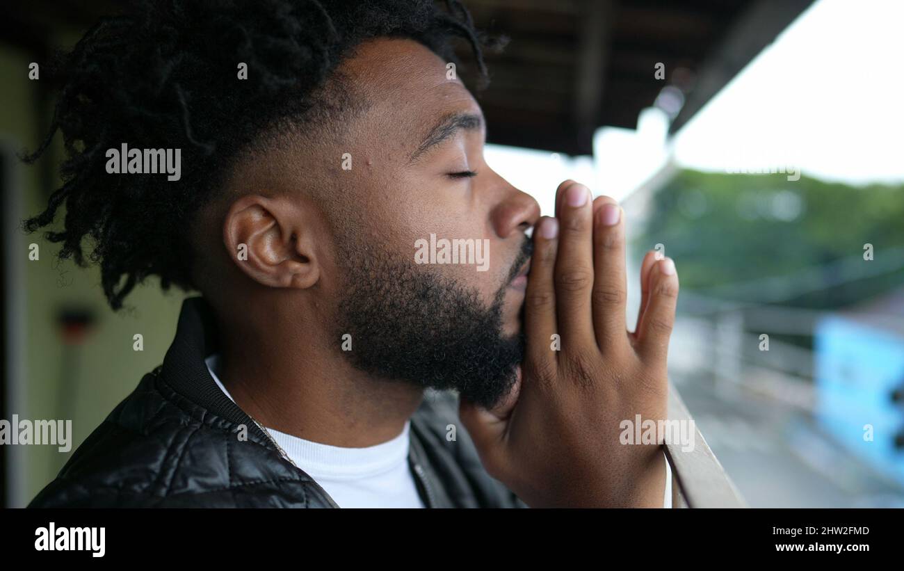 A Brazilian man praying to God opening eyes smiling Stock Photo - Alamy