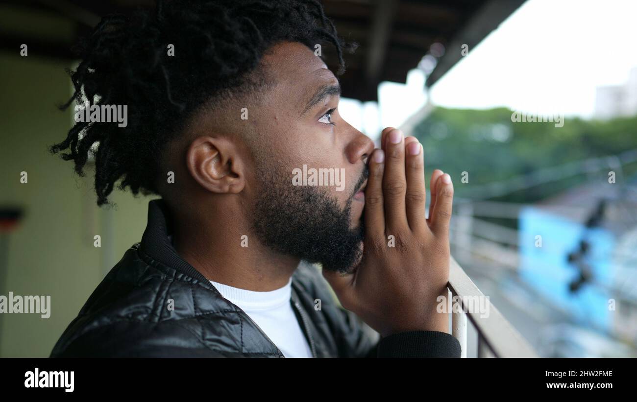 A Brazilian man praying to God opening eyes smiling Stock Photo - Alamy