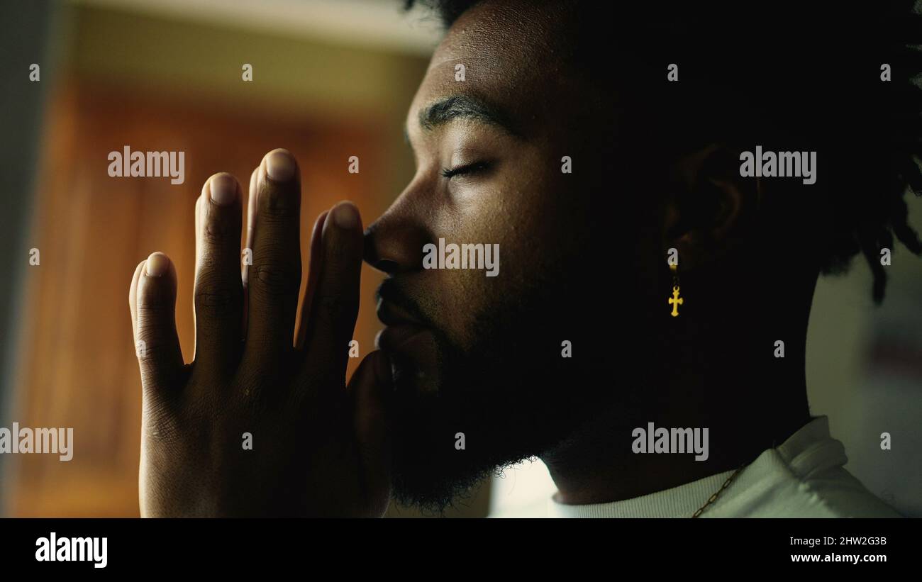 A spiritual black man praying with hands together Stock Photo - Alamy