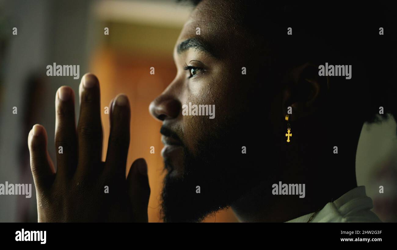 A spiritual black man praying with hands together Stock Photo - Alamy