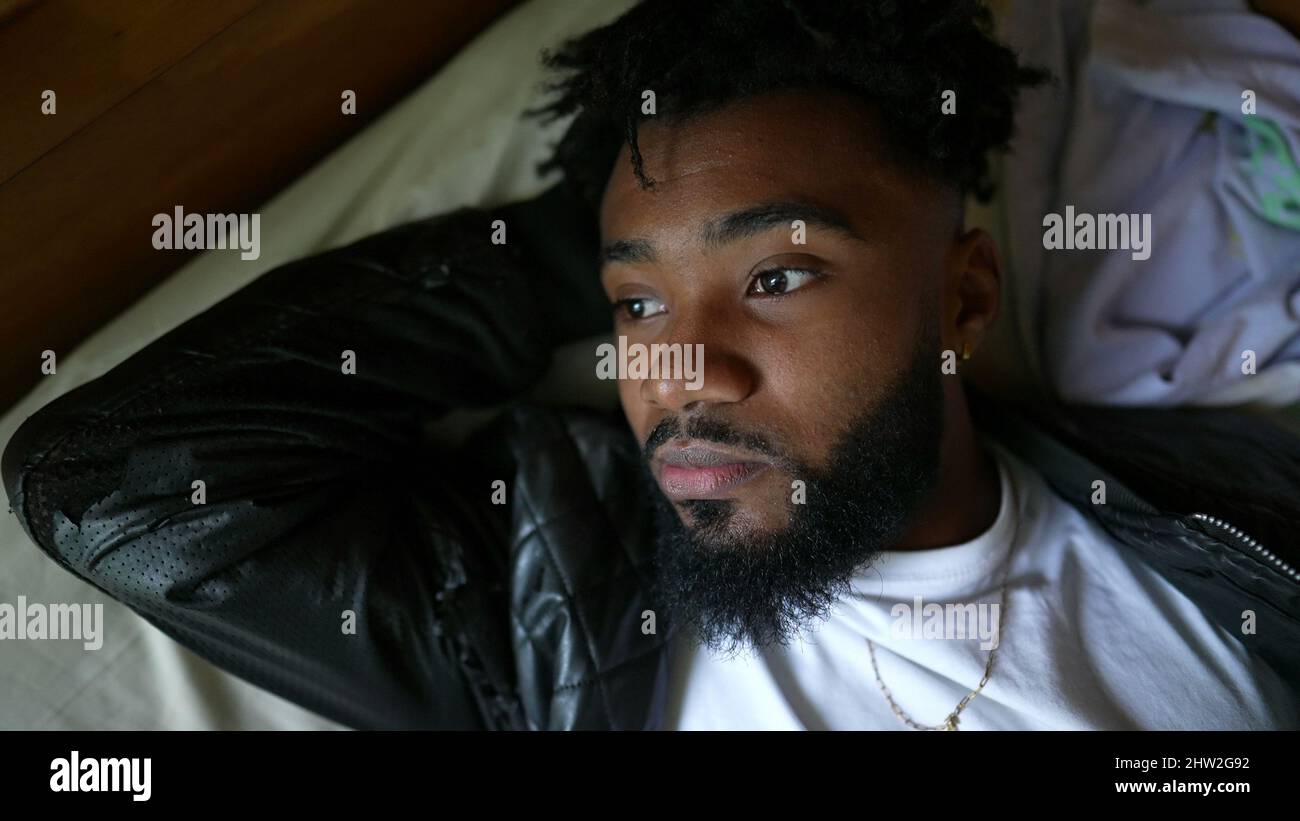 A young black man getting up from bed after rest Stock Photo - Alamy