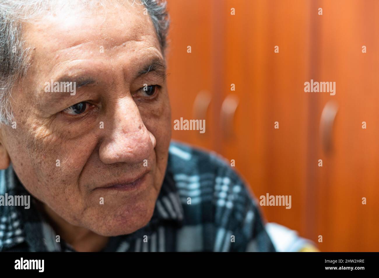 Portrait of happy senior man smiling at home. Old man relaxing on sofa ...