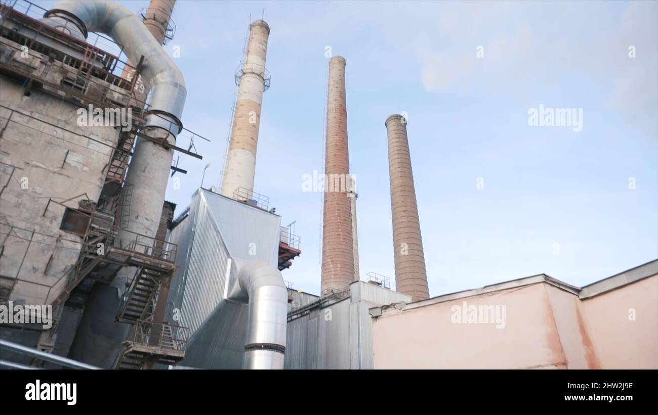 Smoking chimneys of the industrial buildings complex. Bottom view of ...