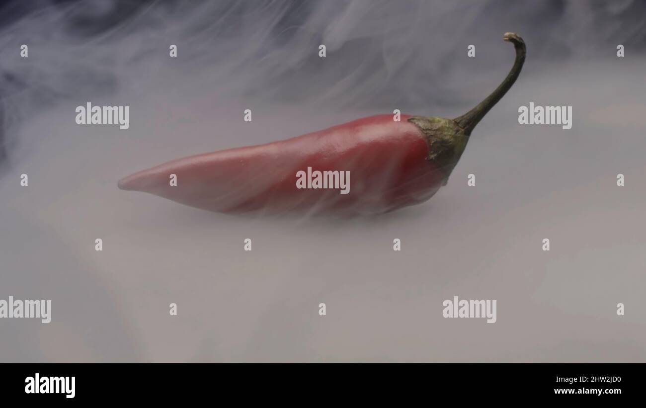 Red hot pepper in smoke. Close up og red hot chilly pepper lying ...