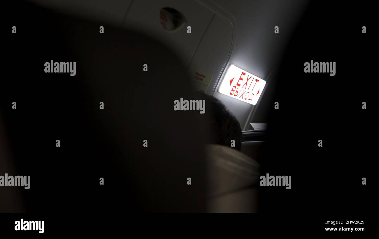Illuminated Exit sign in dark room. Art. Bright sign indicating Exit ...