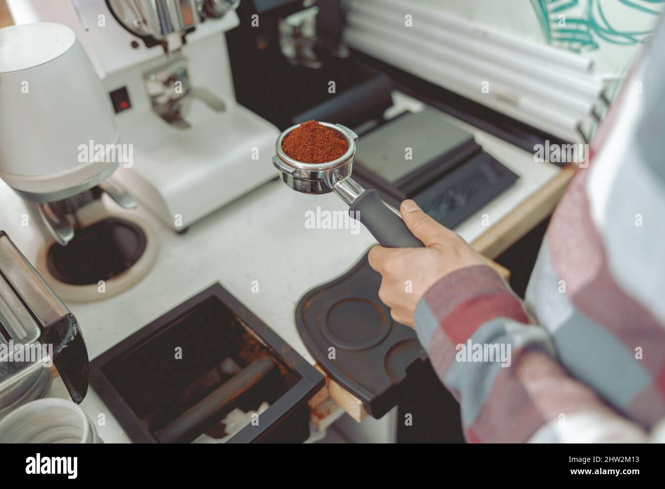 Barista standing near the workplace holding filter in his hands Stock ...