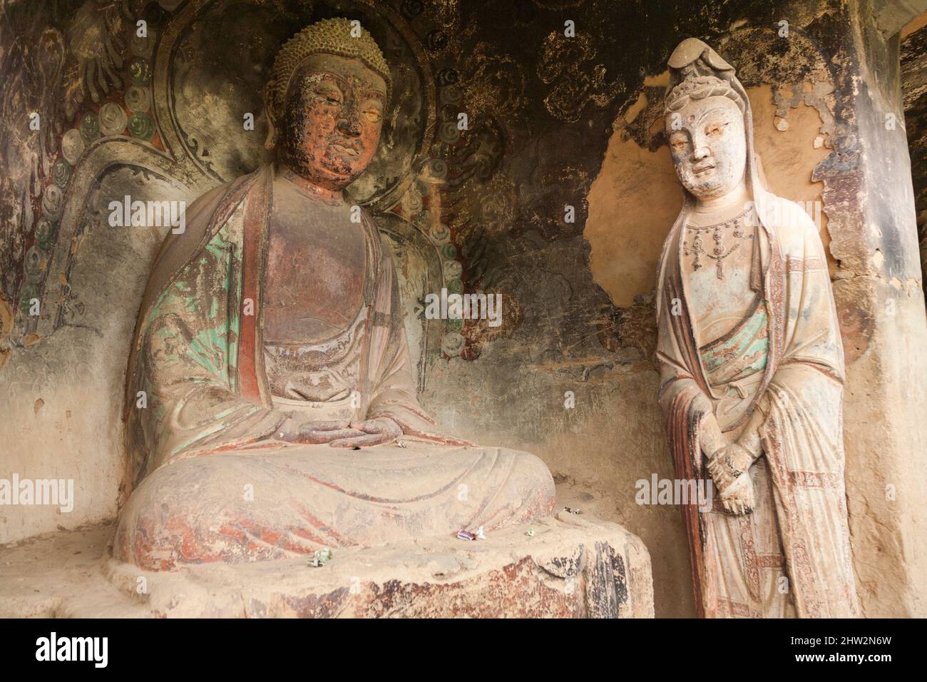 Statues in cave 009. Steps and walkways attached to the sheer rockface ...