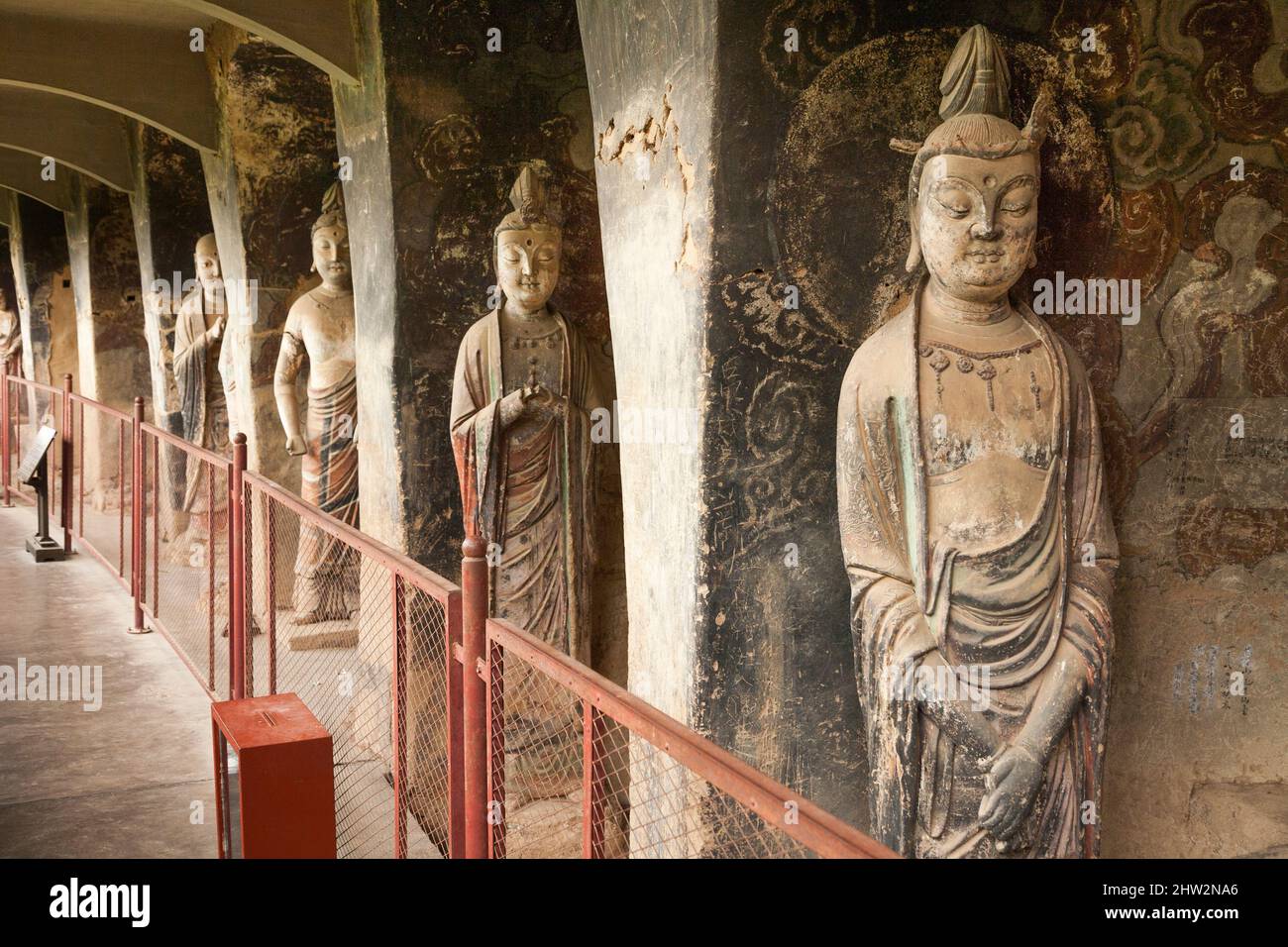 Statues in cave 009. Steps and walkways attached to the sheer rockface ...