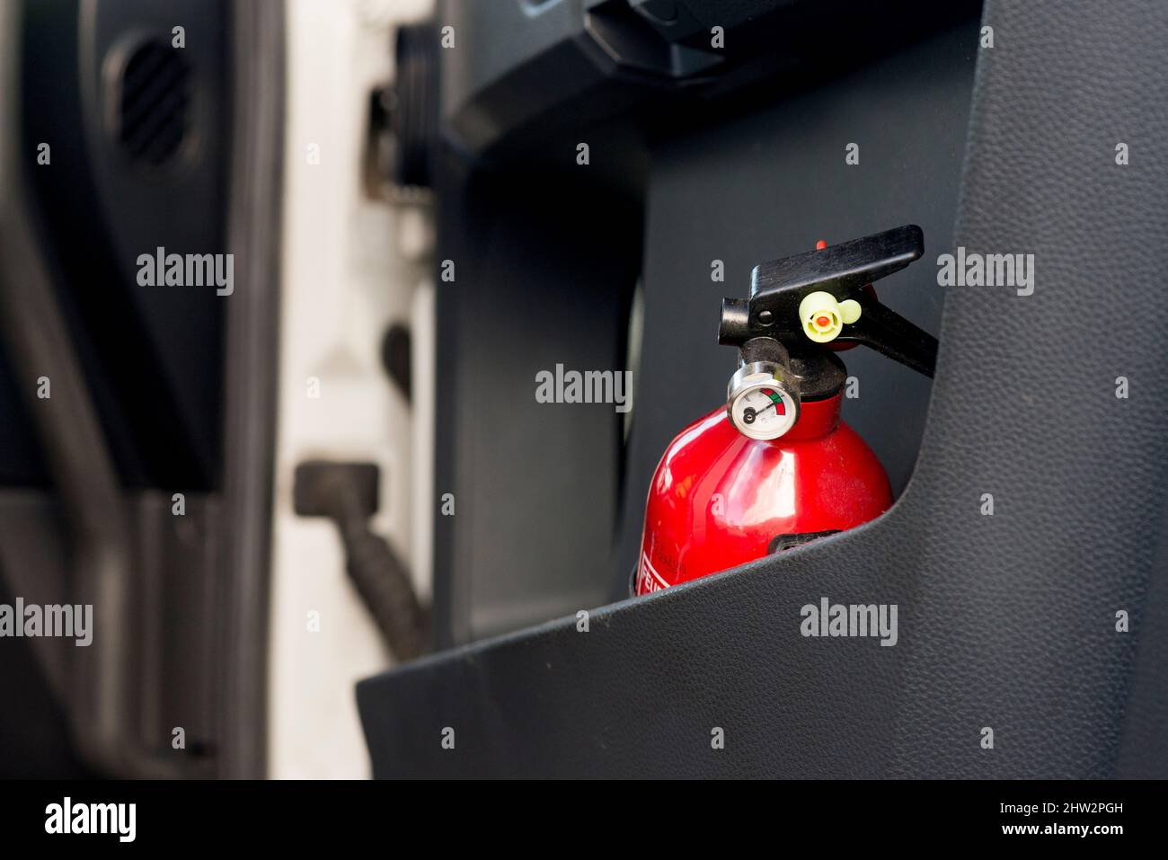 Red fire extinguisher in a black truck door Stock Photo - Alamy