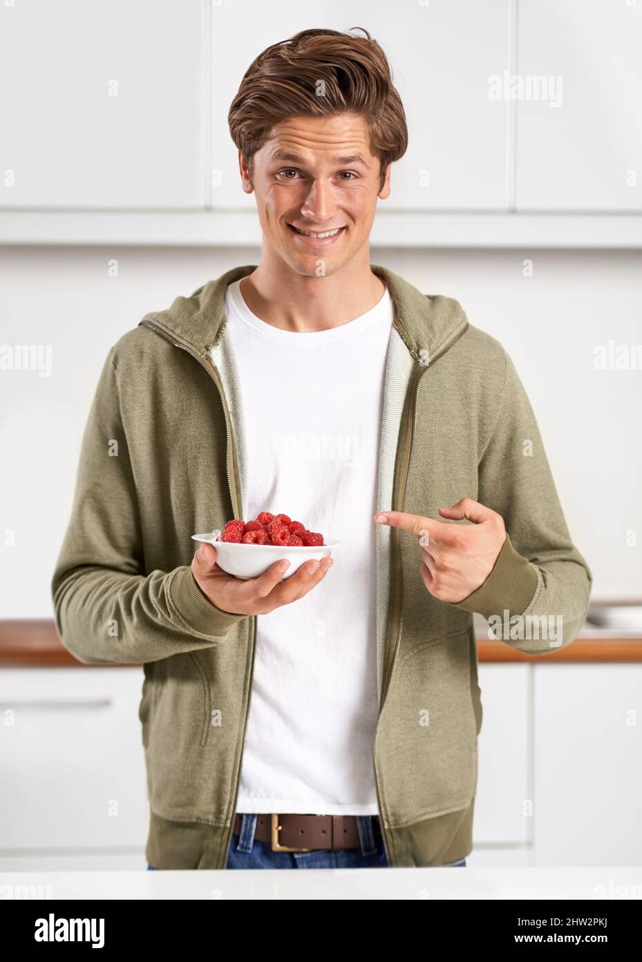 Are these juicy berries all for me. A handsome young man pointing to a ...