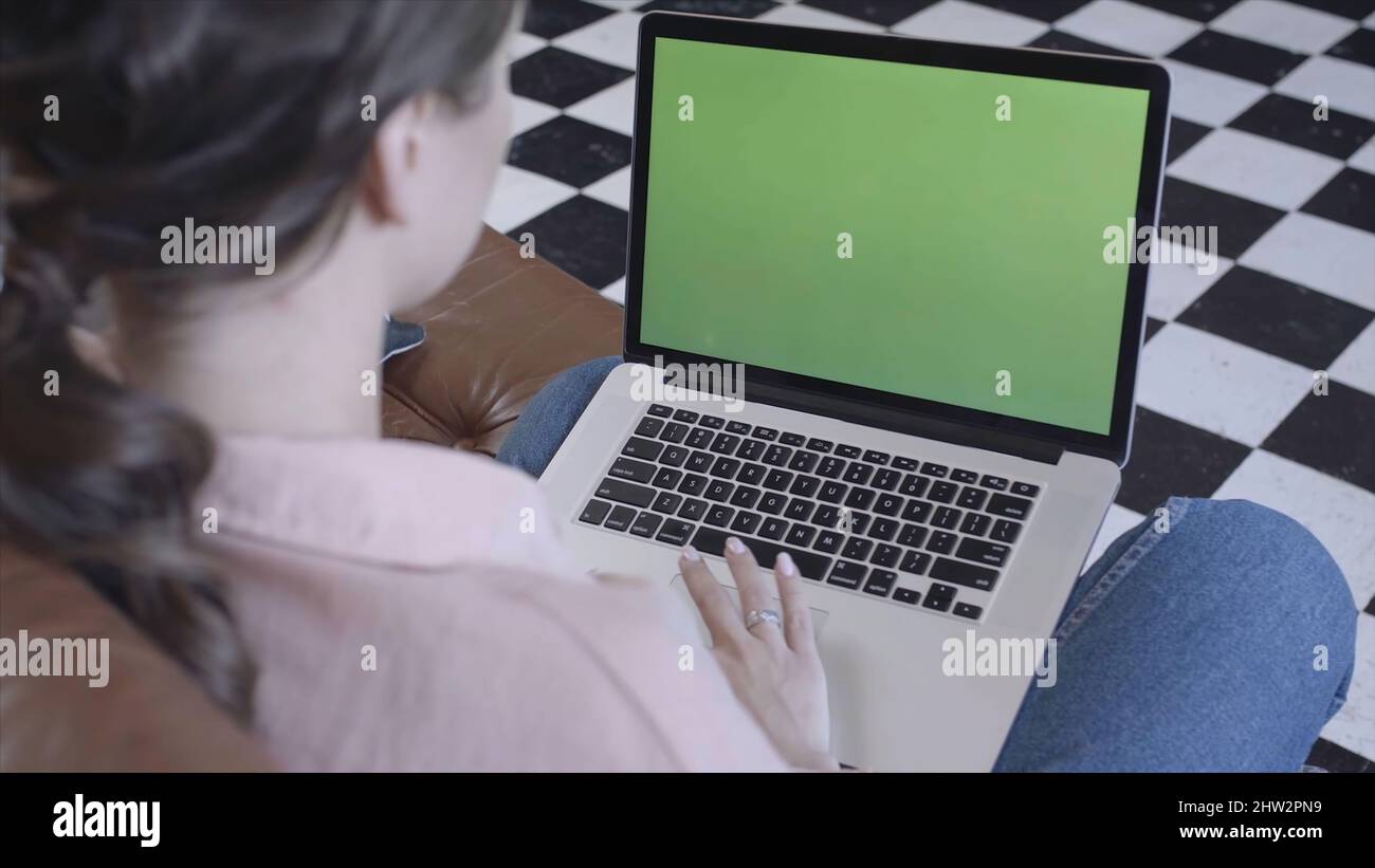 New technology concept. Young woman in pink at home typing on the ...