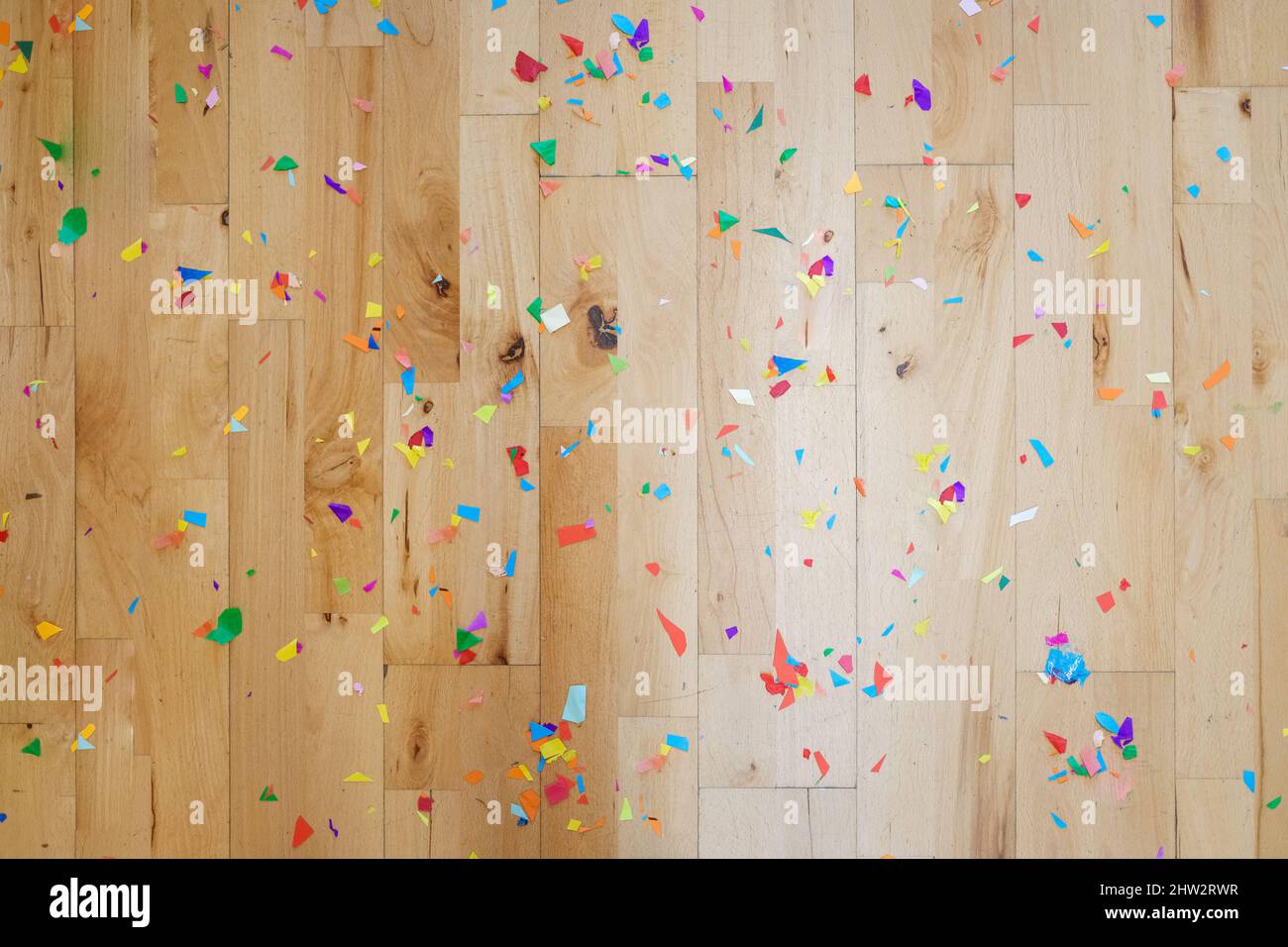 Confetti covers the wooden floor after a celebration, background for ...