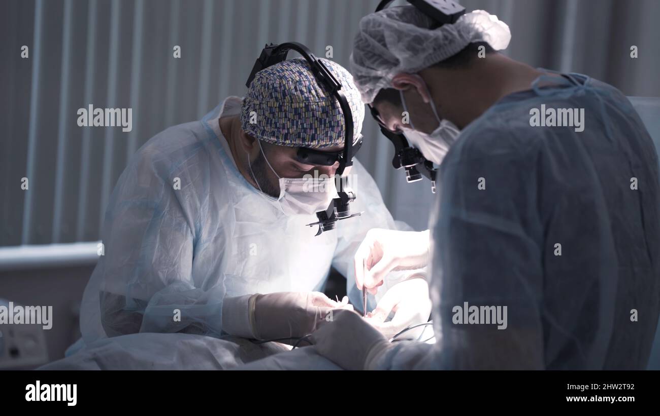 Surgeons perform operation under anesthesia. Action. Two professional ...