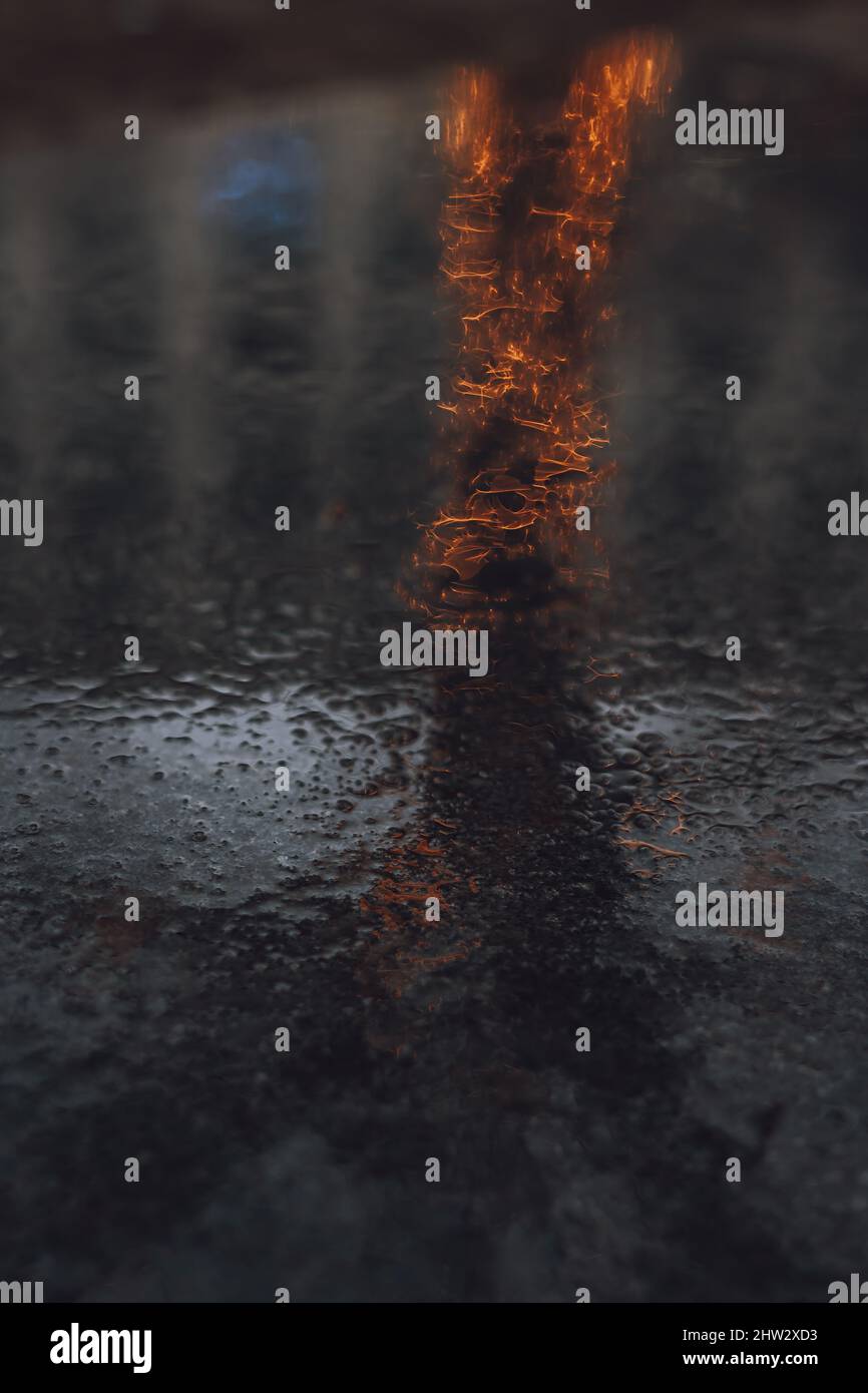 A vertical shot of wet asphalt texture with the reflection of evening ...