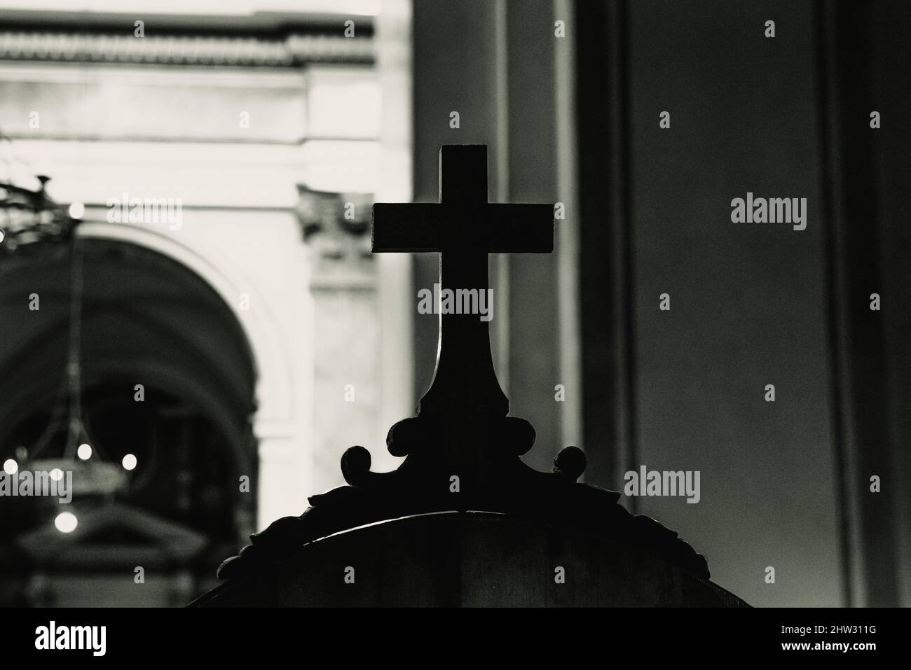 Religious wooden cross on a confessional in the dark interior of a ...