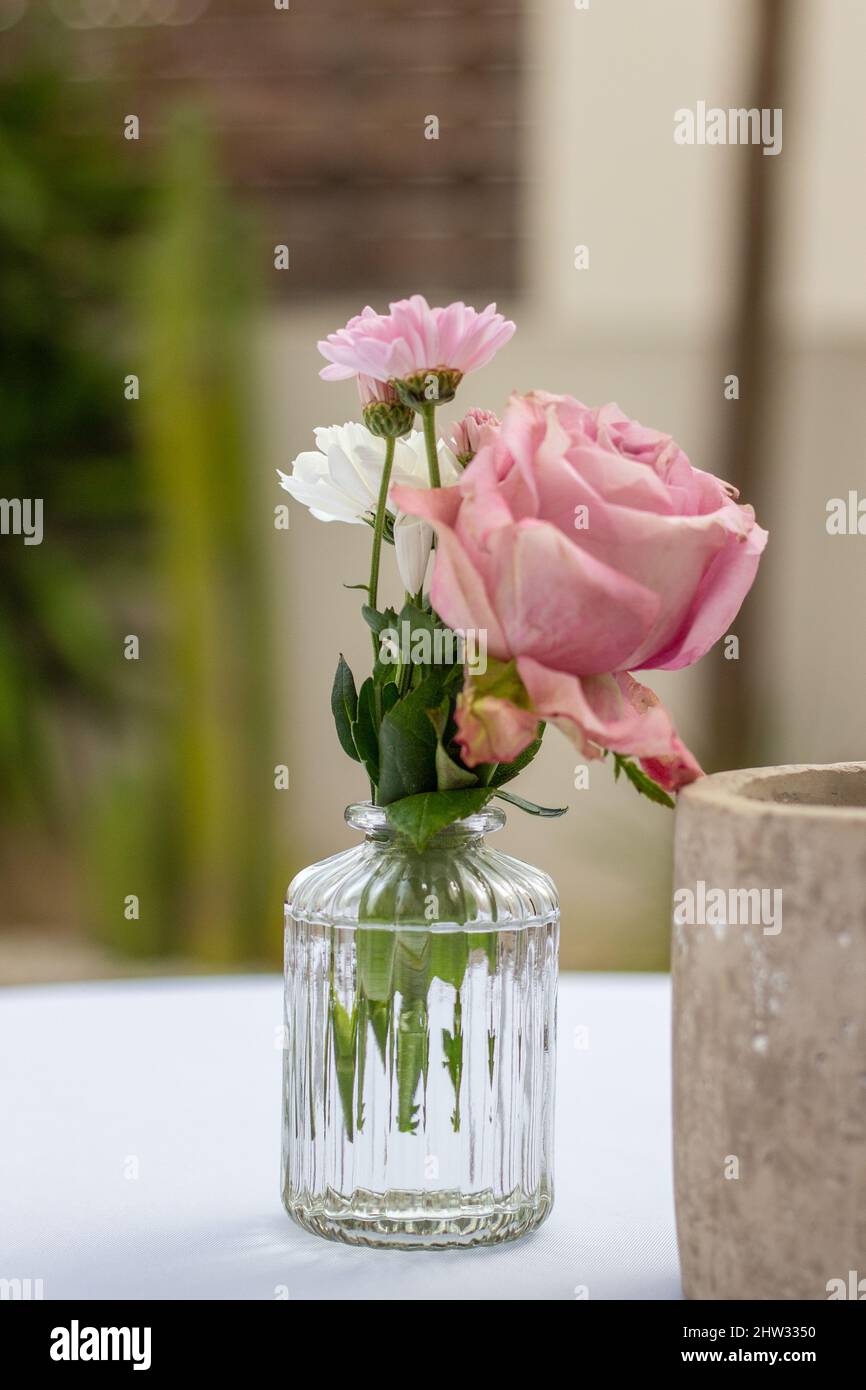 Vertical shot of pink flowers in a glass vase on a table Stock Photo ...