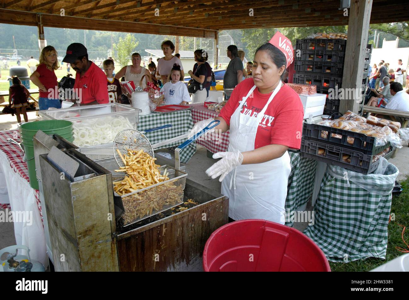 Woman making battered French fries and Onion Rings for party in deep ...