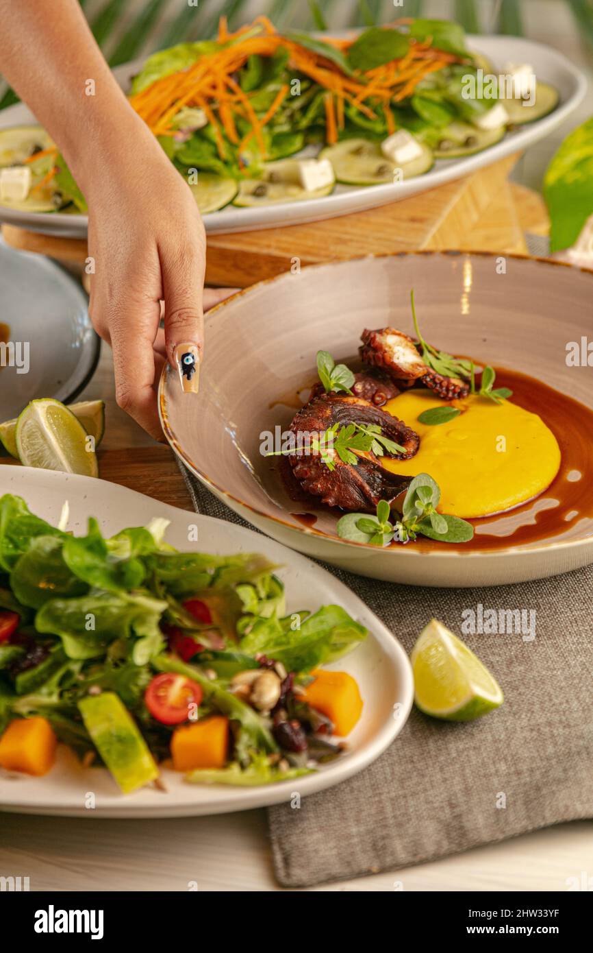 Closeup of an octopus with puree on a plate Stock Photo - Alamy