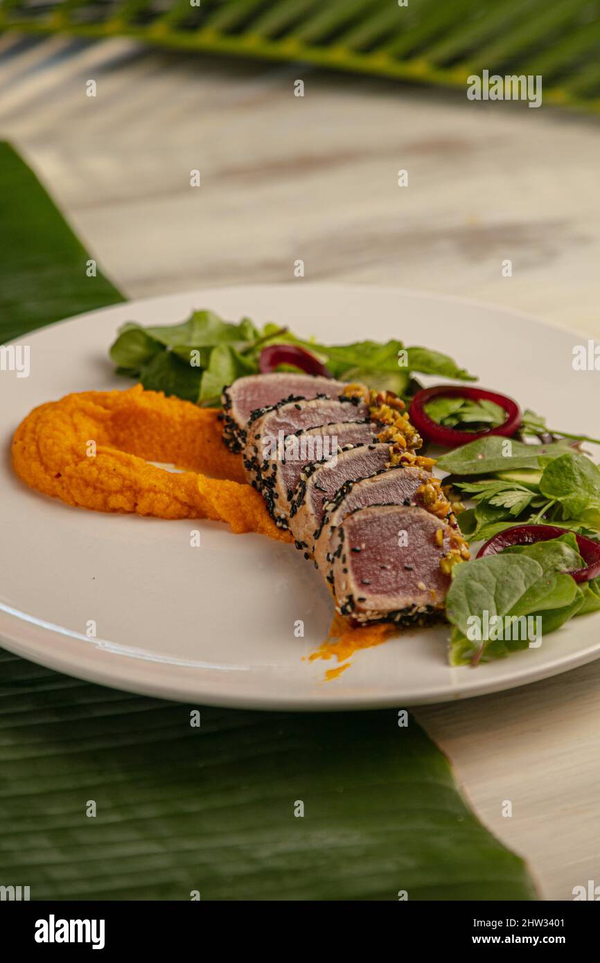 Top view of a tuna steak with greens and sauce Stock Photo - Alamy