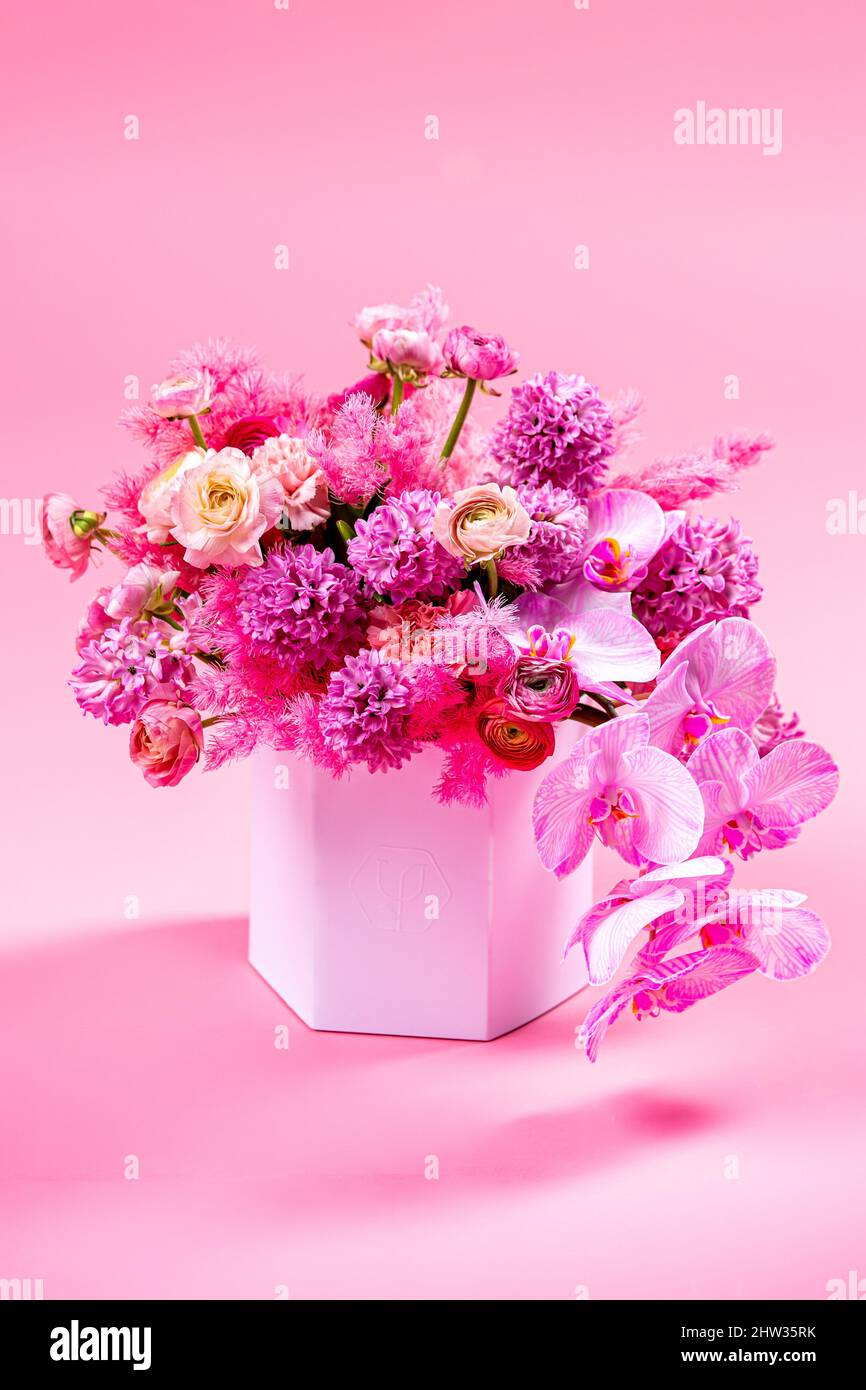Bouquet of flowers in cardboard box on a pink background Stock Photo ...