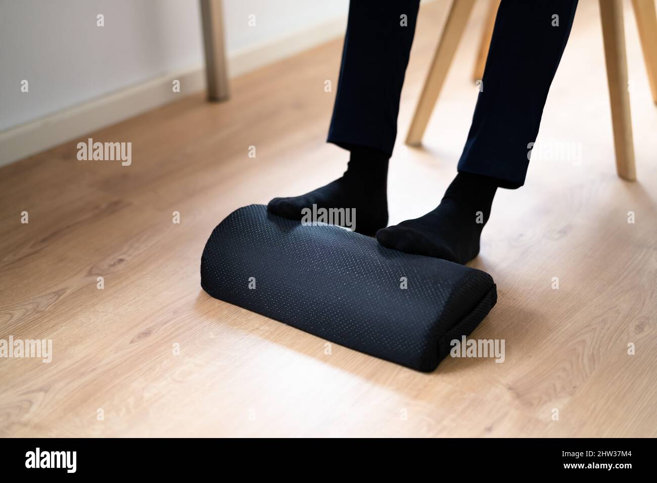 Worker Using Footrest To Reduce Back Strain And Feet Fatigue Stock ...