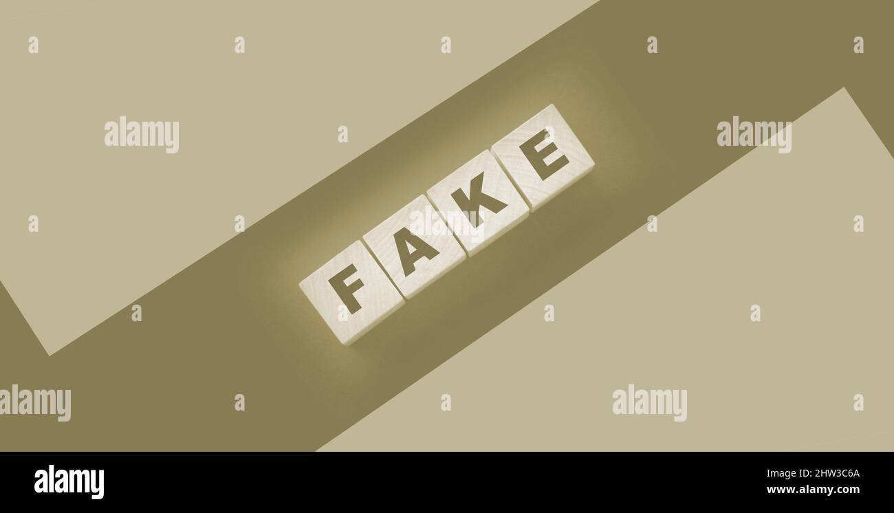 FAKE word written in wooden blocks on black background Stock Photo - Alamy