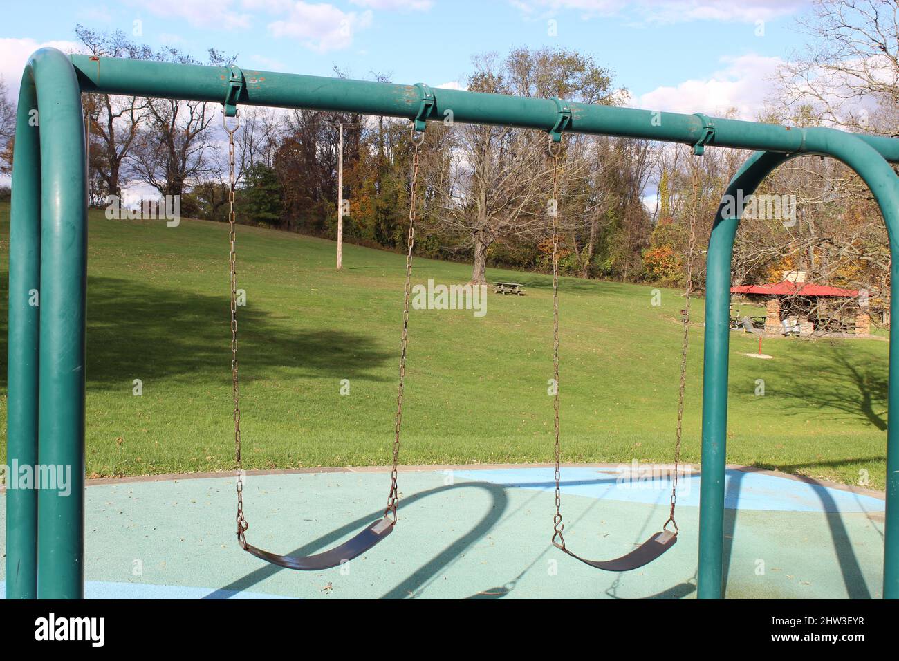 Steel playground swing set with a filed Stock Photo - Alamy
